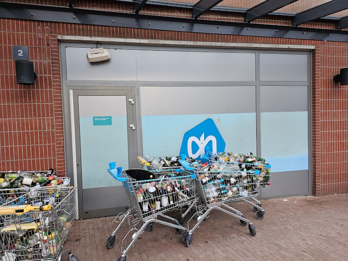In Hengelo staat een karretje met lege flessen, en boa's houden het in ...