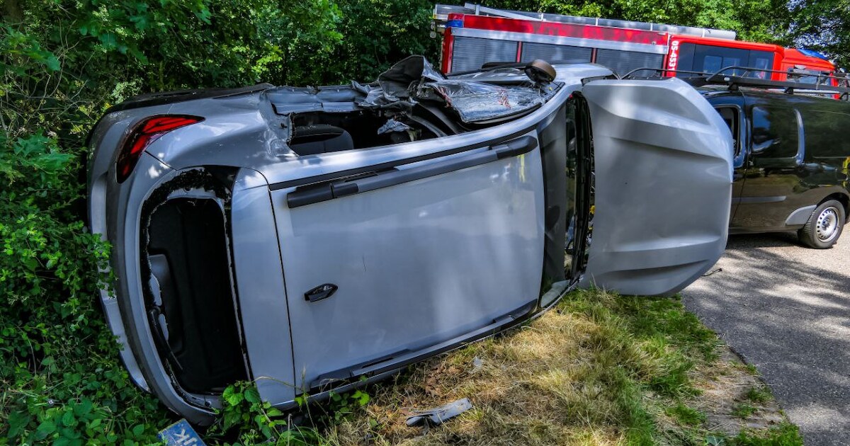 Auto op de zijkant na zware aanrijding in Buurse, brandweer bevrijdt ...